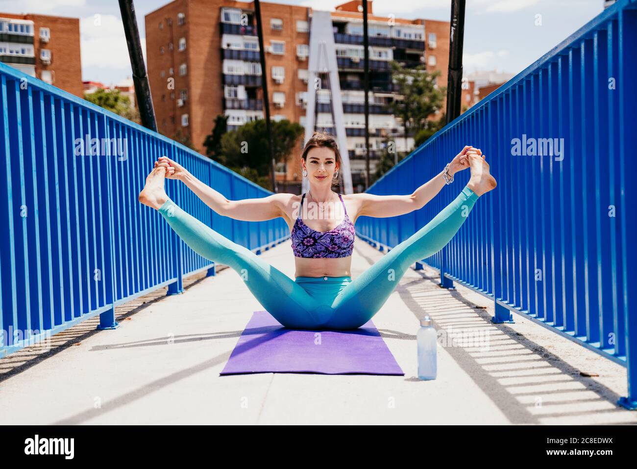 Beautiful woman stretching body while practicing yoga on bridge Stock ...