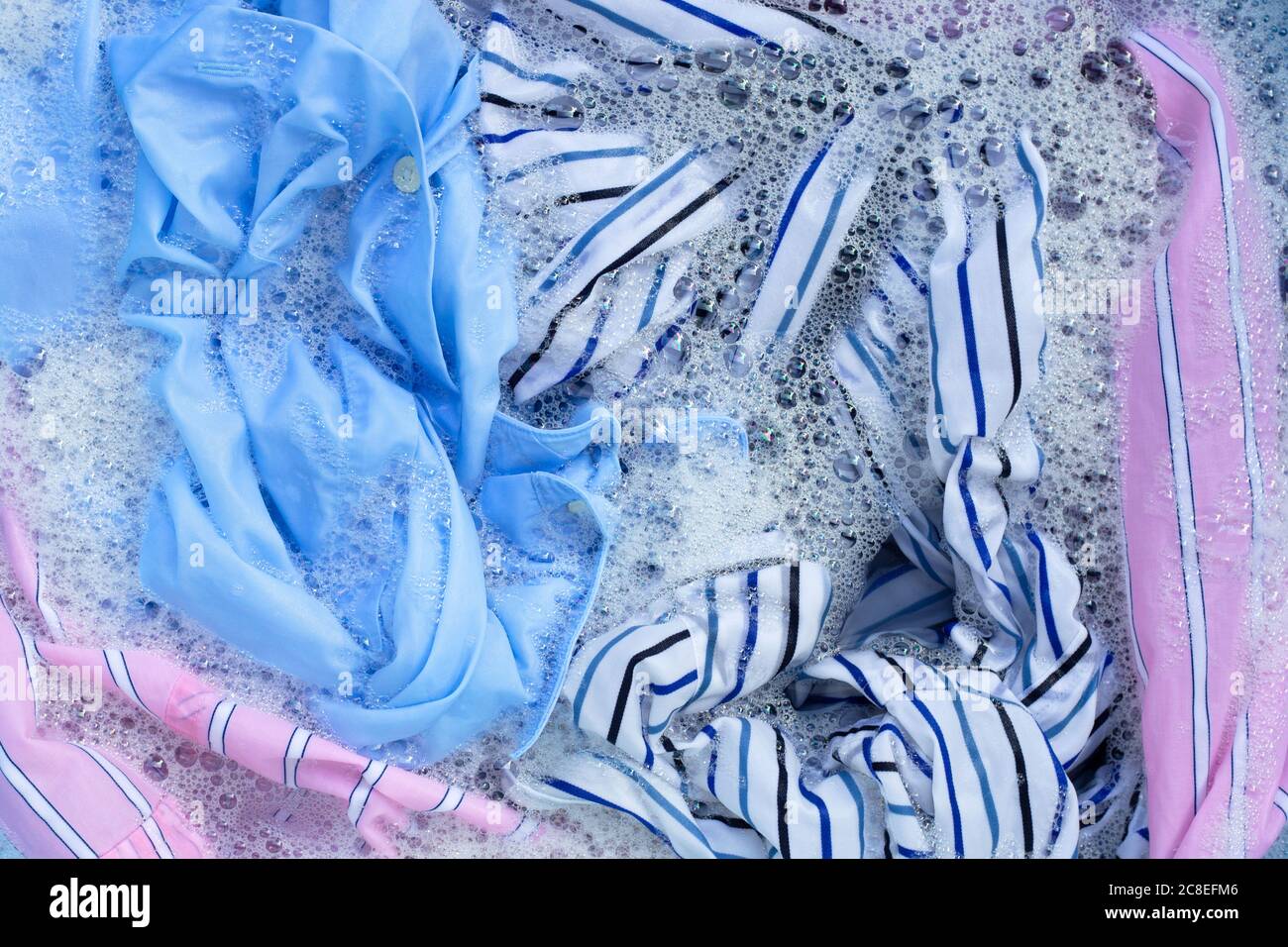 Top view of color clothes soak in powder detergent water dissolution ...