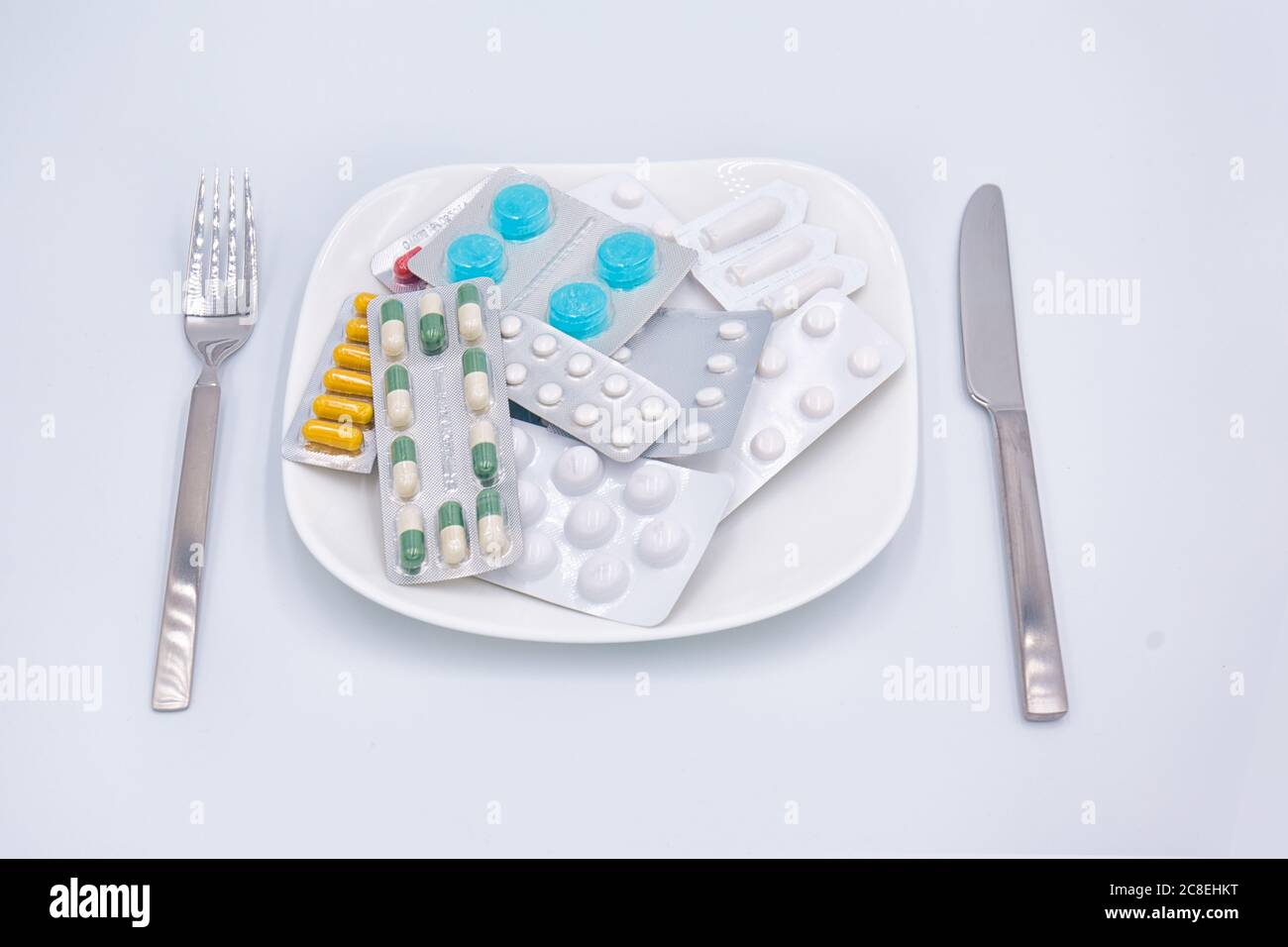 Diet. Different pills, medicines, drugs on a white square shaped plate ...