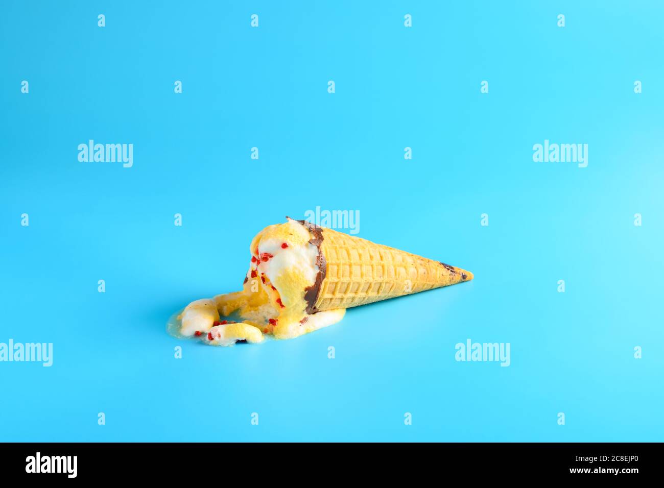 pineapple and cherry flavor ice cream cone in a melting process on a ...