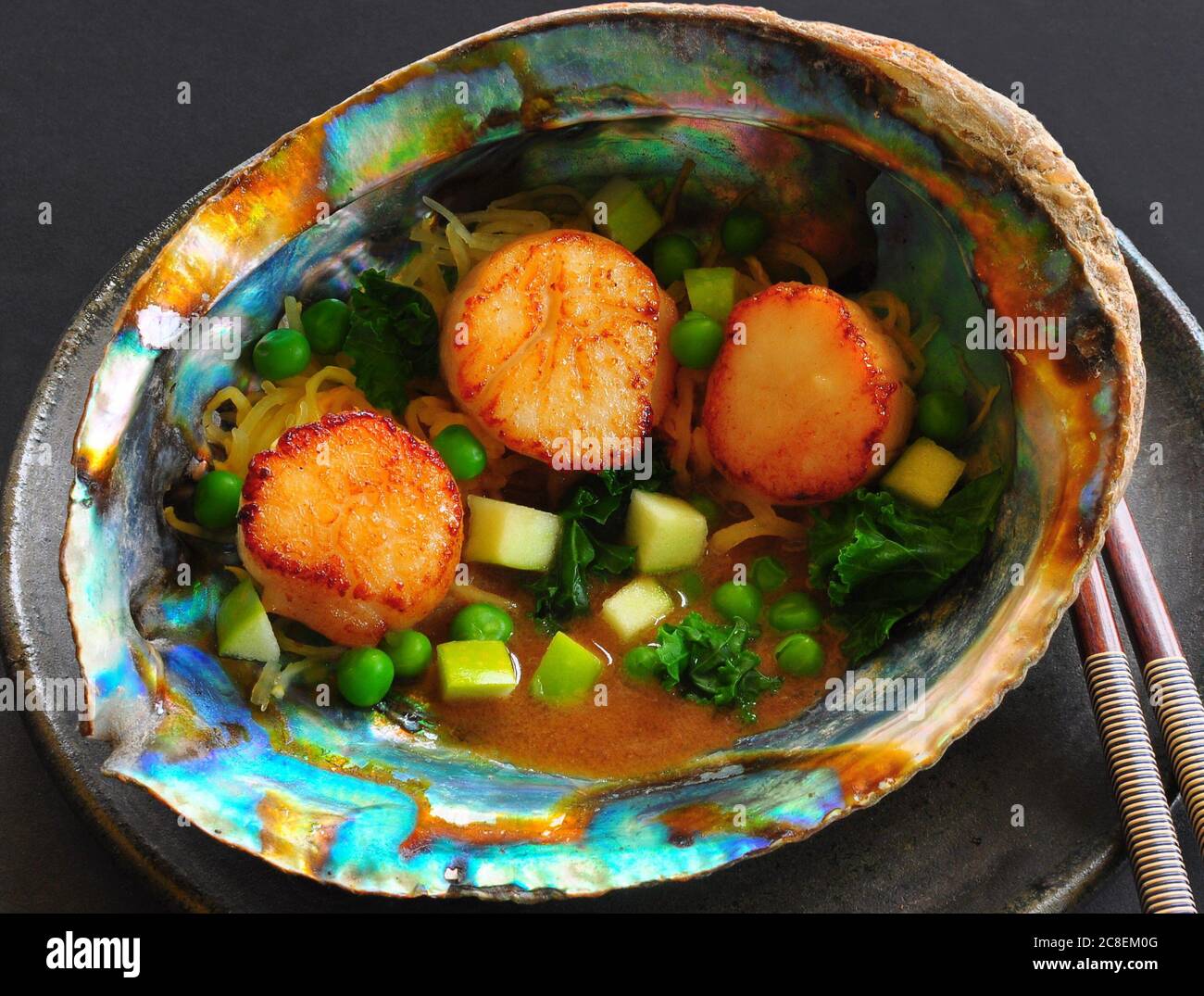 Seared Scallops served in an abalone shell with vegetables, green ...