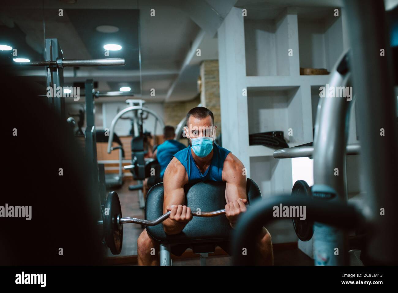 A young caucasian athlete man with a mask on his face exercises and ...