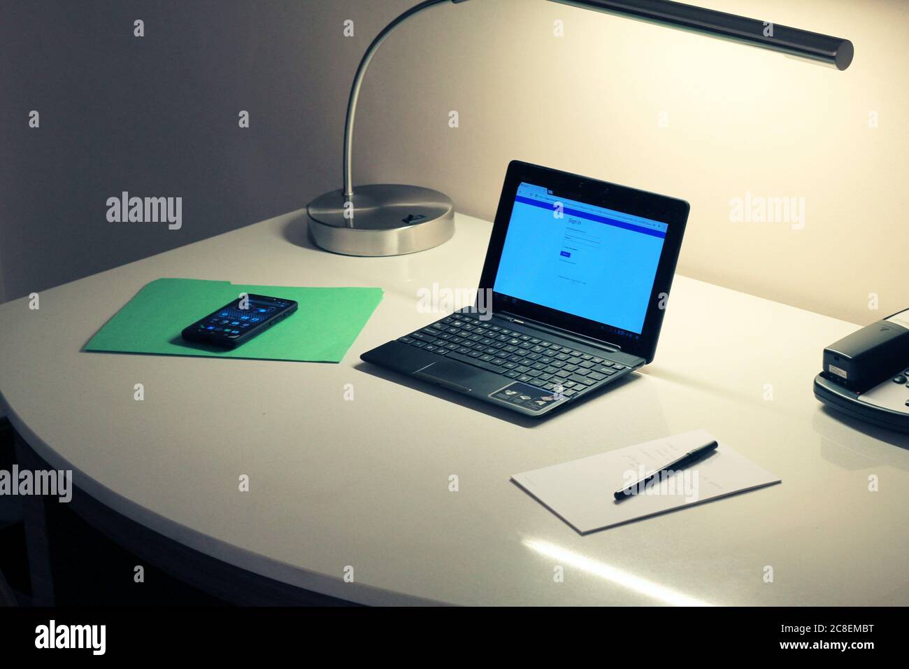 Workplace in hotel room with laptop, notebook, lamp and more Stock ...