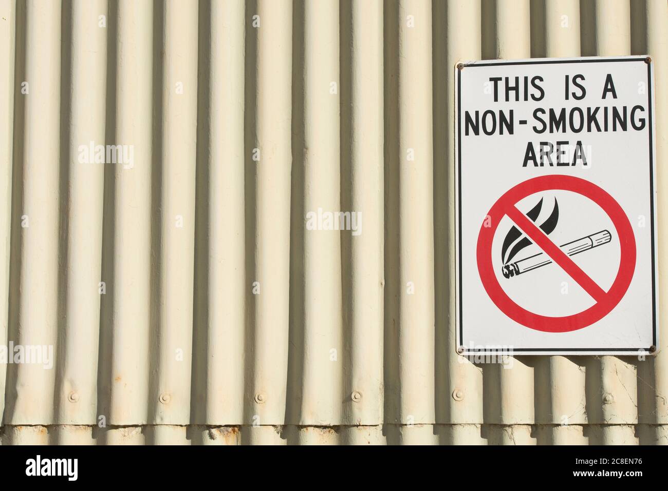 No smoking sign outside wall of building. Warning of health risk. With ...