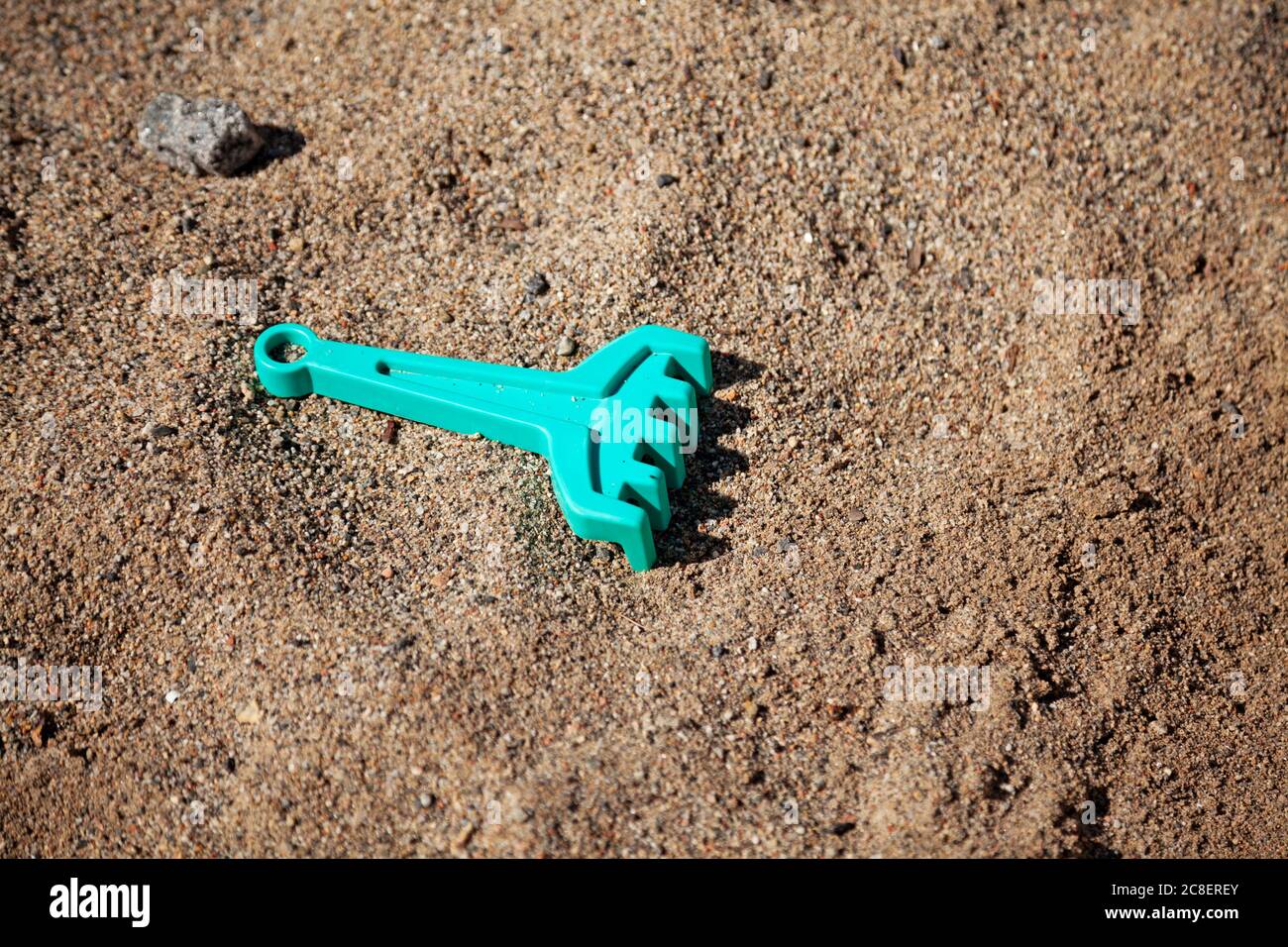 turquoise toy rake lying in the sandbox Stock Photo - Alamy