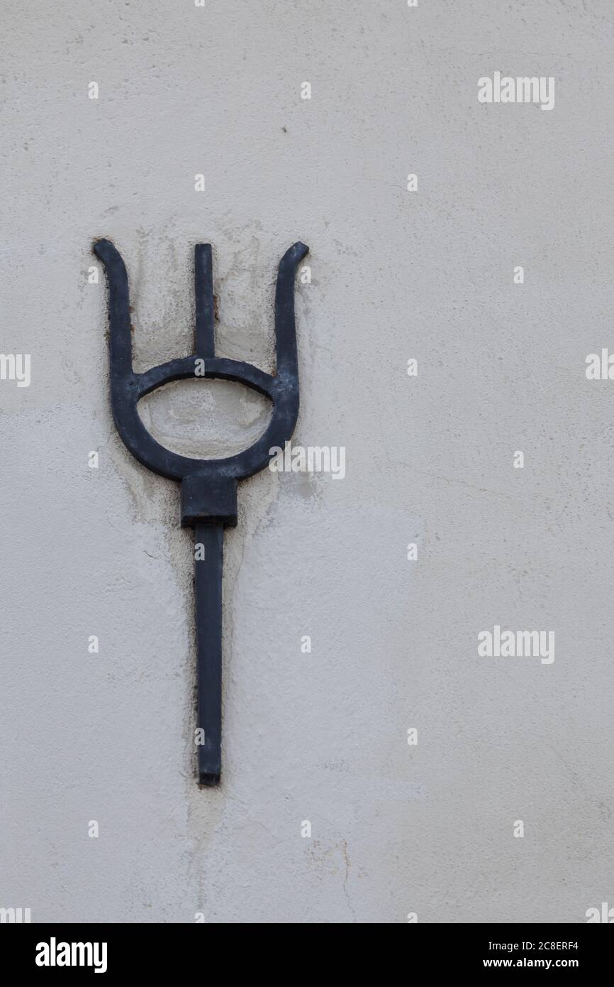 mysterious symbol reminiscent of an iron trident cast in the concrete ...