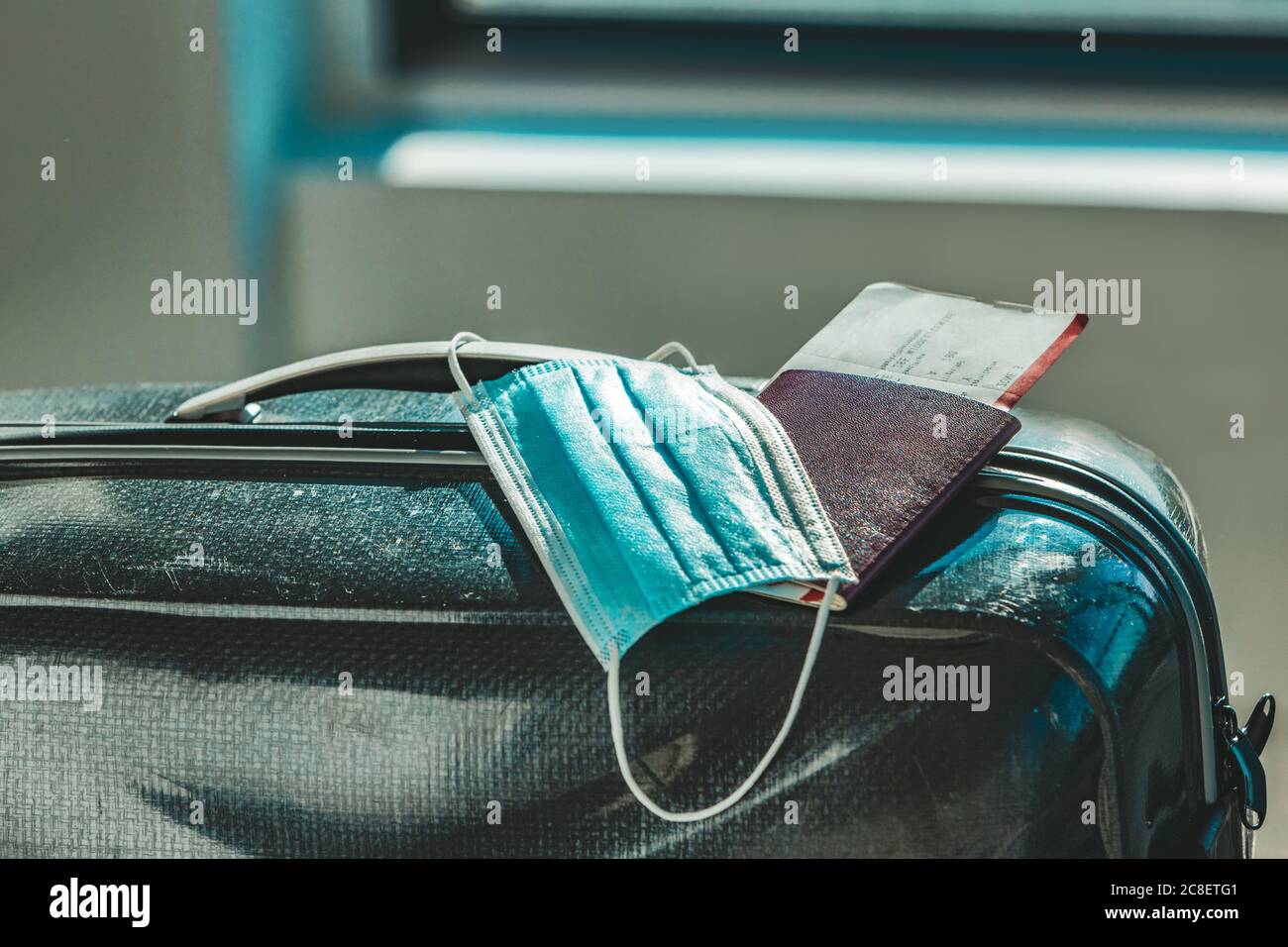 COVID-19 travel mask with luggage. Coronavirus airport restriction. A ...