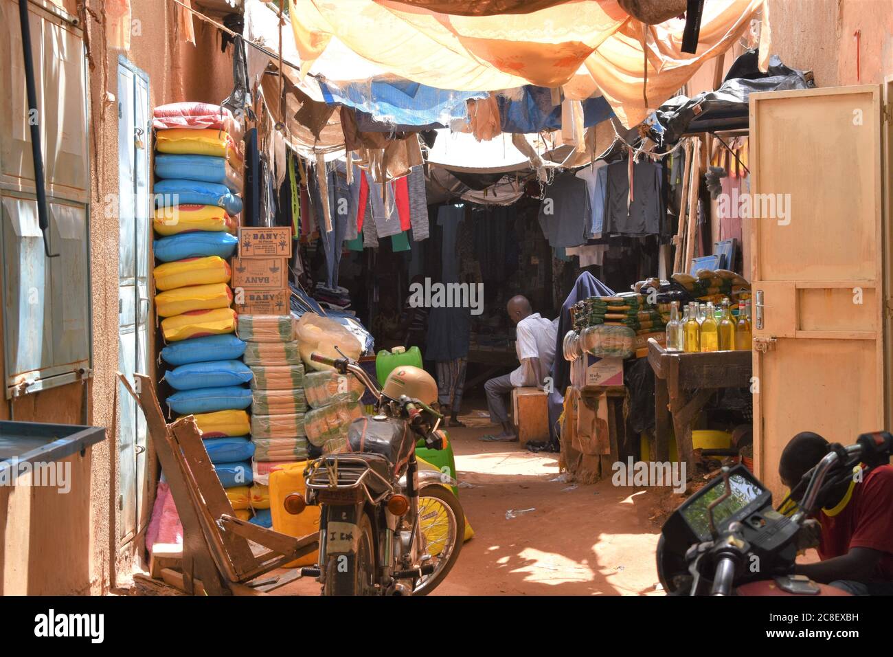 Suspended tarps offer shade to a crowded aisle in an African market ...