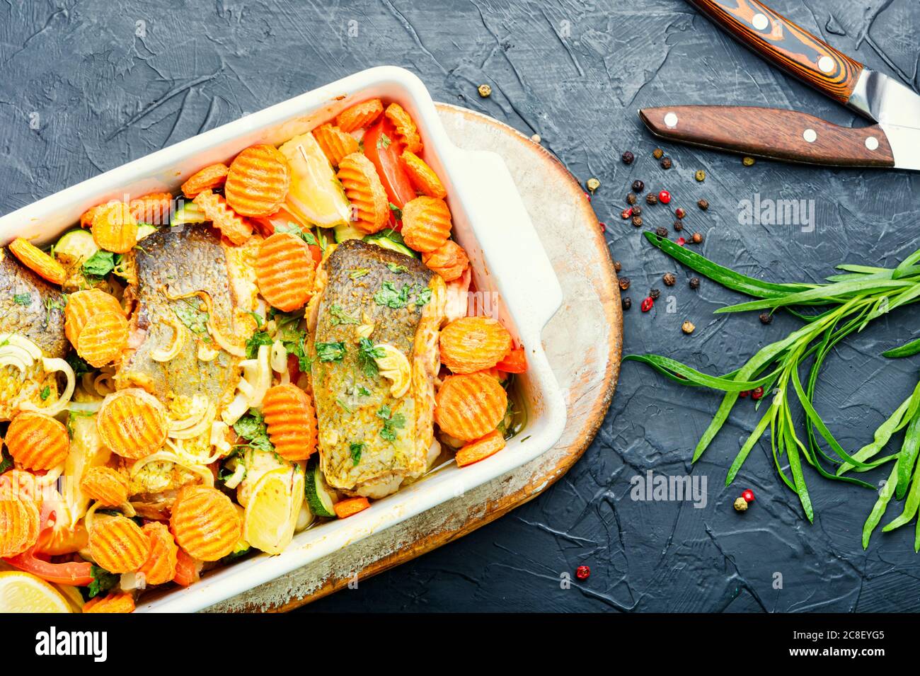 Baked fish steaks with grilled vegetables in baking dish.Delicious ...