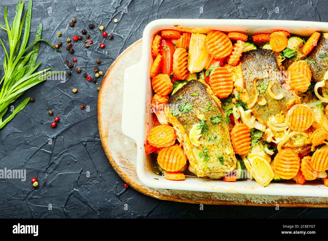 Baked fish steaks with grilled vegetables in baking dish.Delicious ...