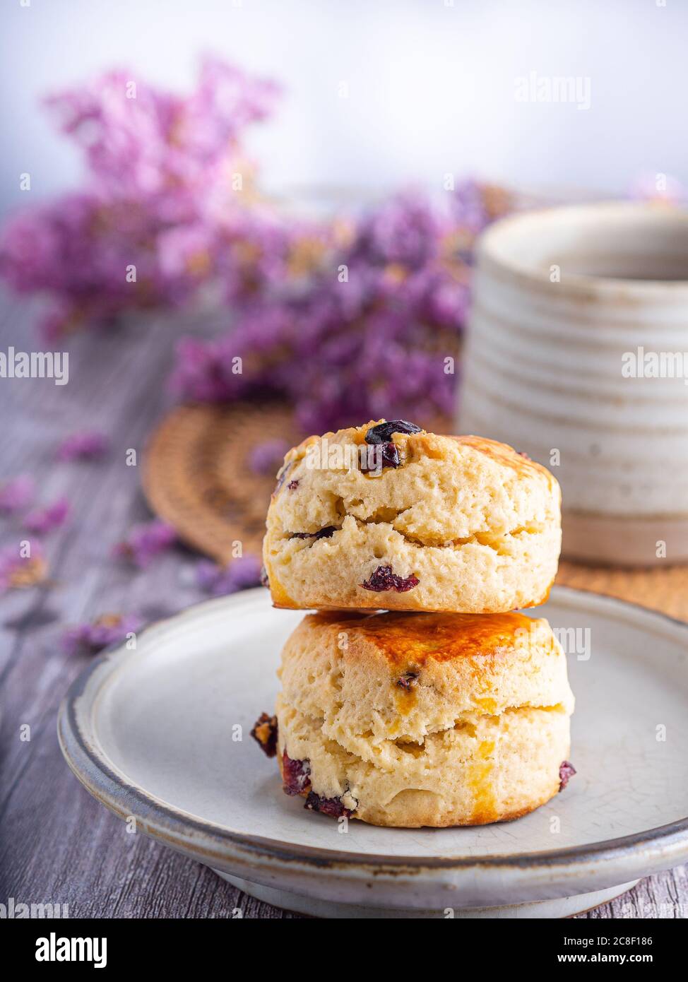 Close-up of traditional British scones on a plate with a tea cup and ...