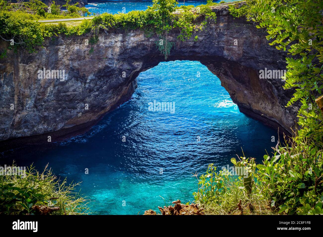 Rock coastline. Stone arch over the sea. Broken beach, Nusa Penida ...