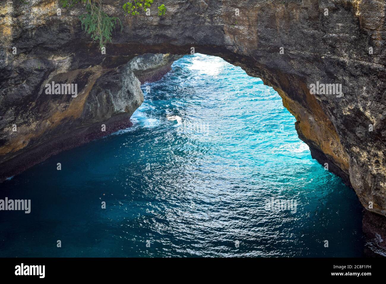 Rock coastline. Stone arch over the sea. Broken beach, Nusa Penida ...