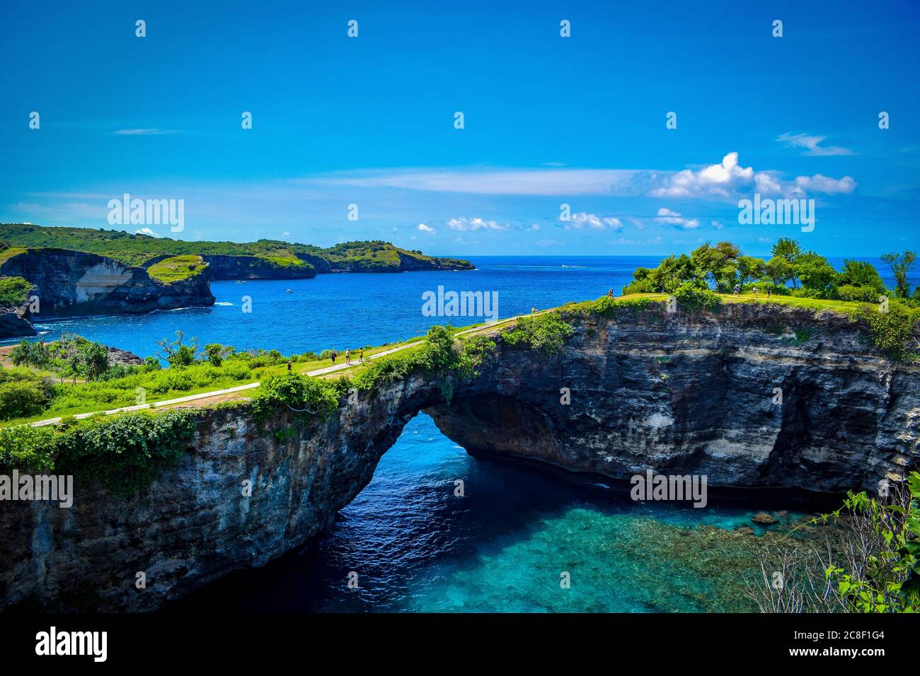 Rock coastline. Stone arch over the sea. Broken beach, Nusa Penida ...