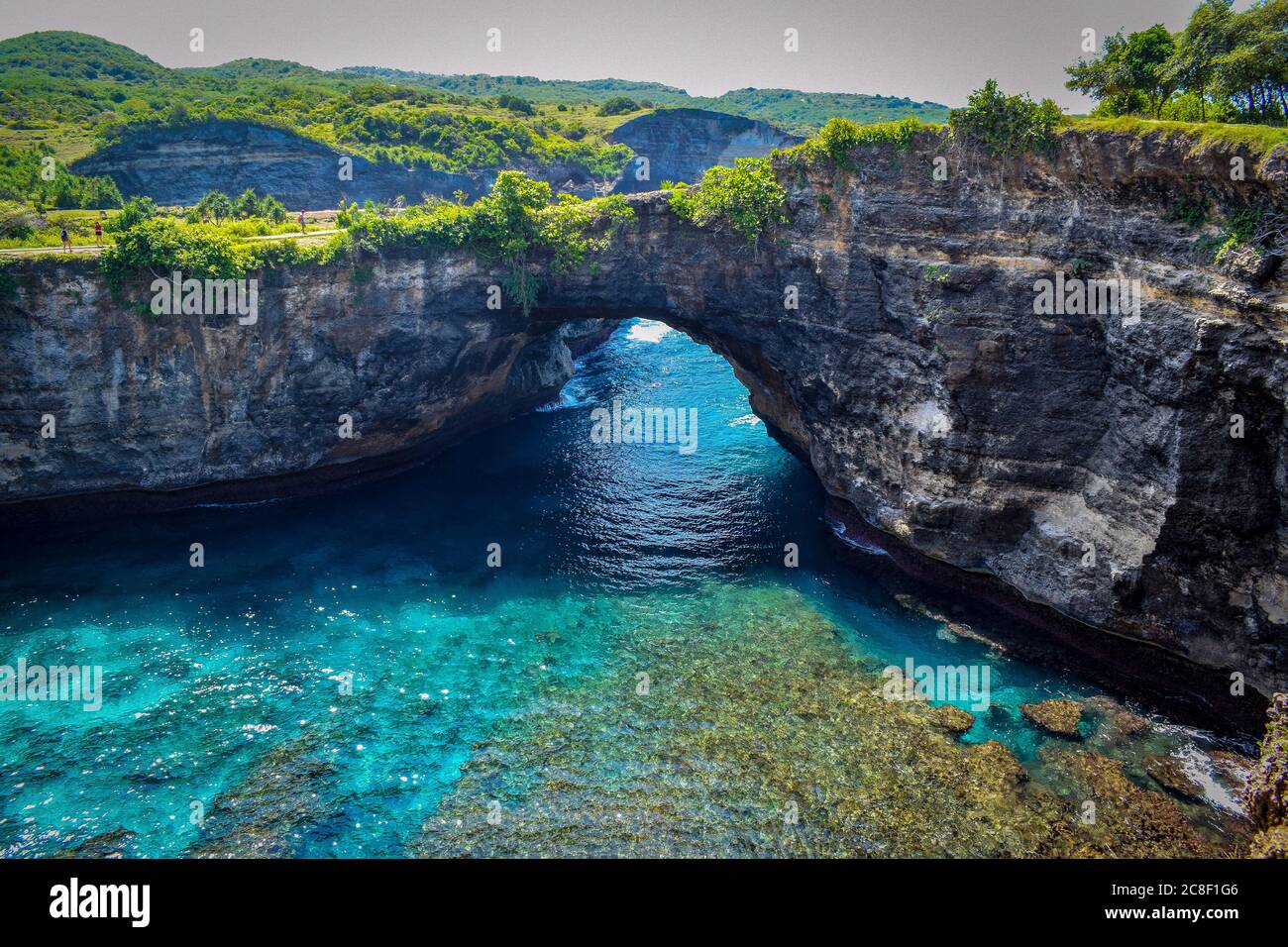 Rock coastline. Stone arch over the sea. Broken beach, Nusa Penida ...