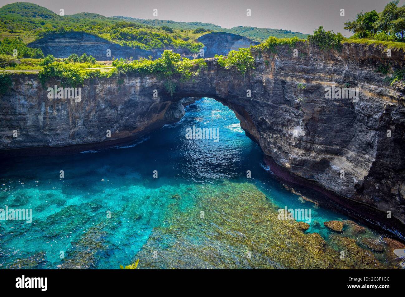 Rock coastline. Stone arch over the sea. Broken beach, Nusa Penida ...