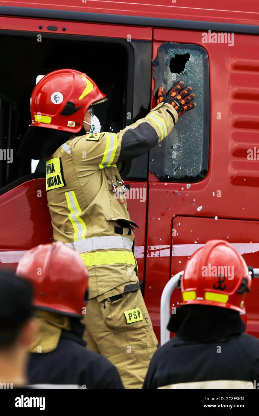 Firefighter brakes a window of a truck cabin during excercise. The ...