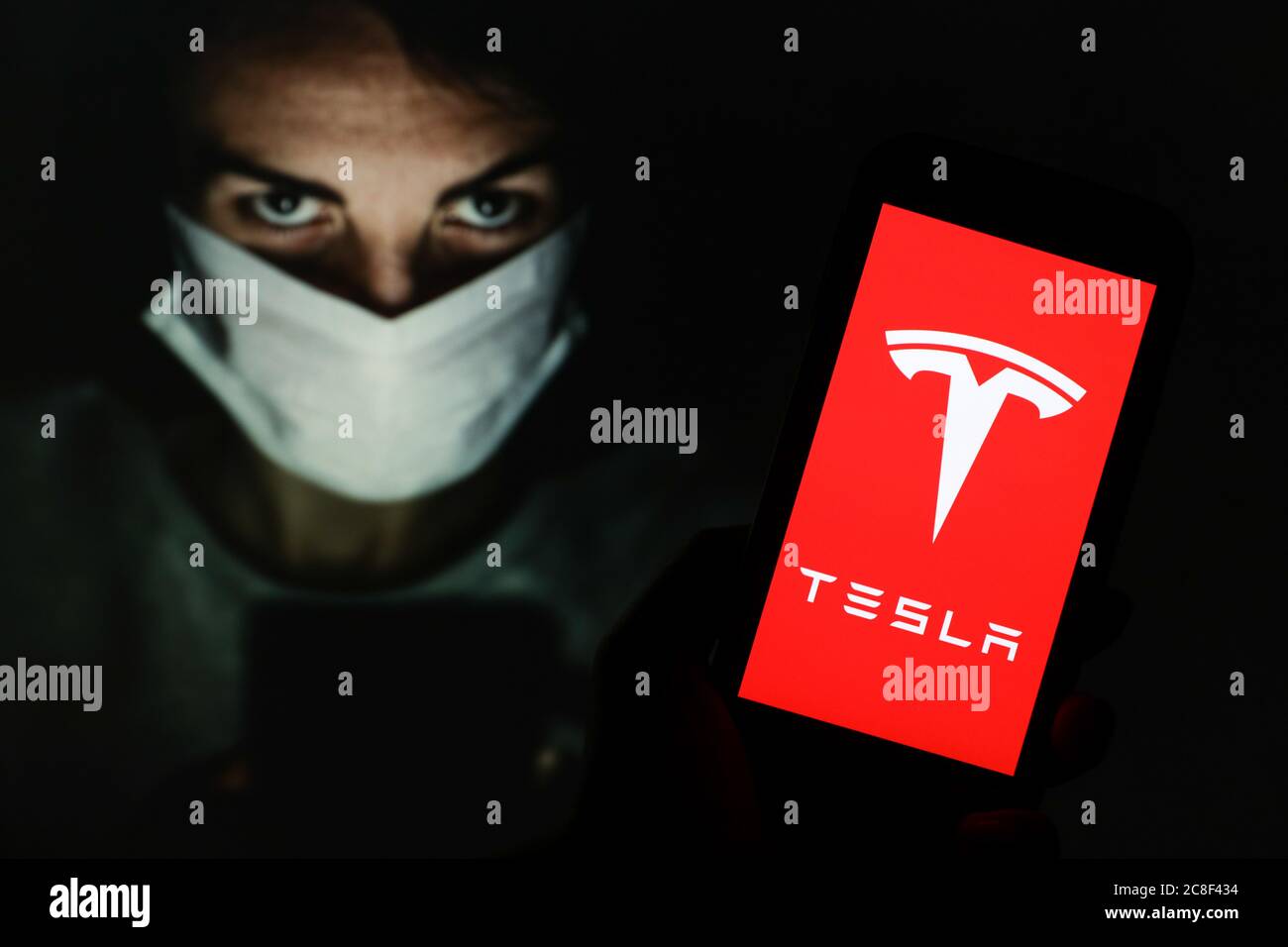 In this photo illustration a Tesla logo seen displayed on a smartphone ...