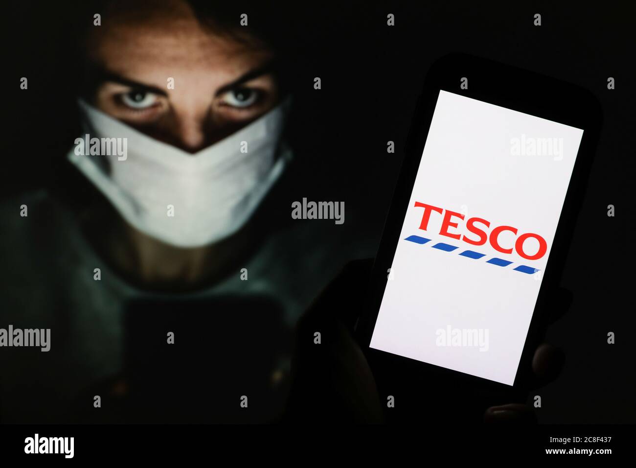 In this photo illustration a Tesco company logo seen displayed on a ...