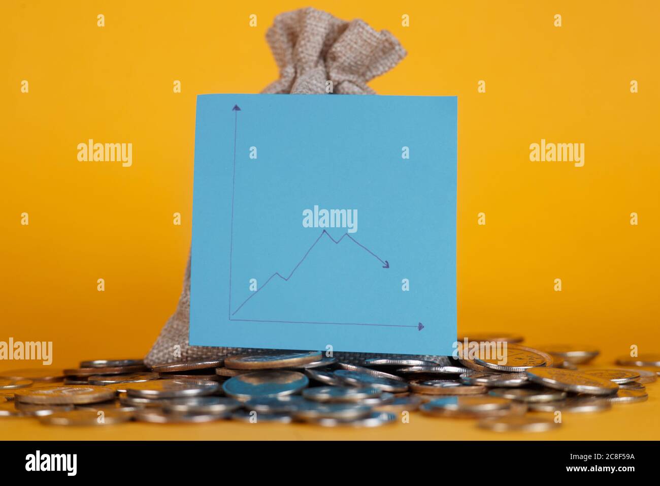 money bag with coins on a yellow background Stock Photo - Alamy