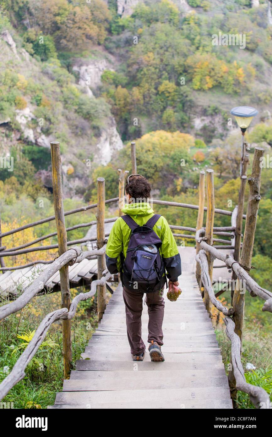 A visitor walks down a wooden walkway to the cave village of Khndzoresk ...