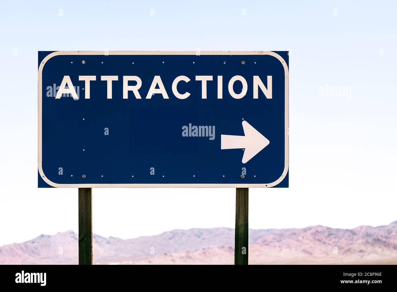 Horizontal shot of a blue rectangular attraction sign in a clear blue ...