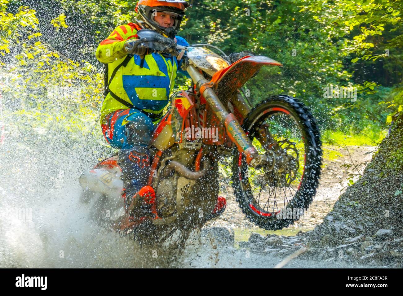 Sunny summer day. A lot of splash of water when an athlete lifted the ...