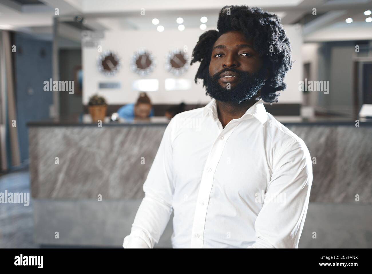 Portrait of a happy african man hotel manager or guest standing against ...