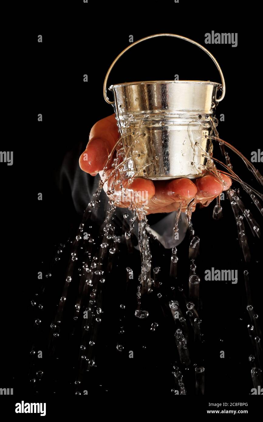 hand holding a tin bucket with holes on black background Stock Photo ...