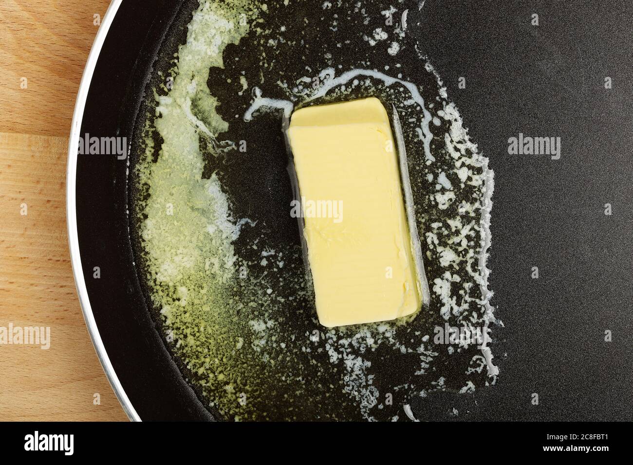 piece of butter while melting in frying pan Stock Photo - Alamy