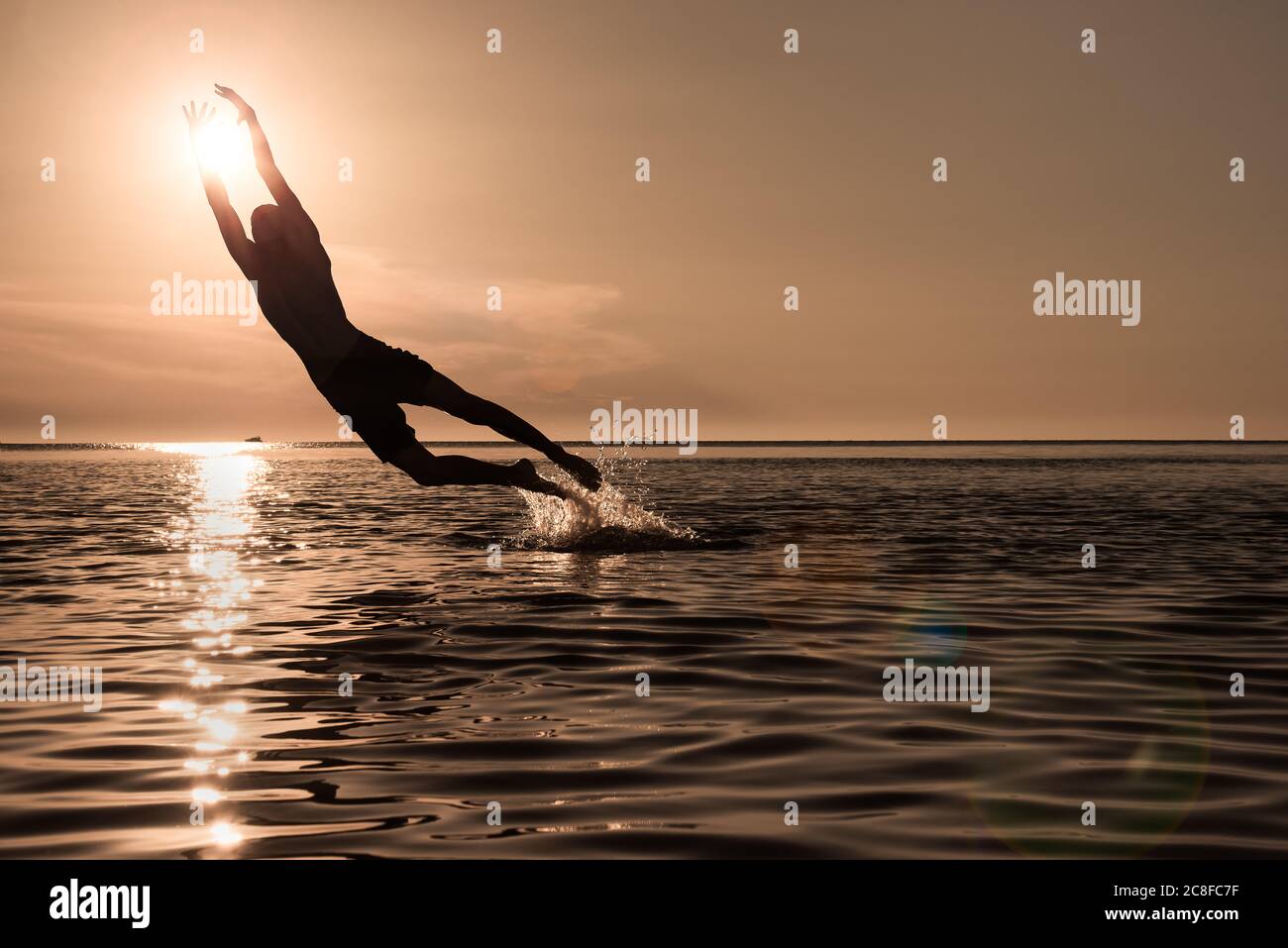 Action shot of boy diving in the sea to catch a soccer ball Stock Photo ...
