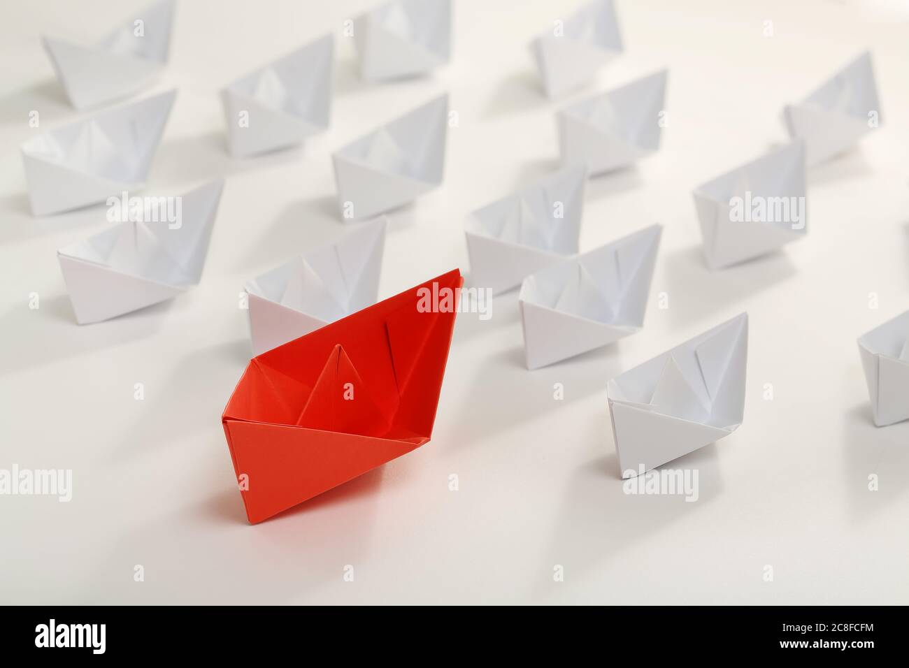 red paper boat leading white ones, leadership concept Stock Photo - Alamy