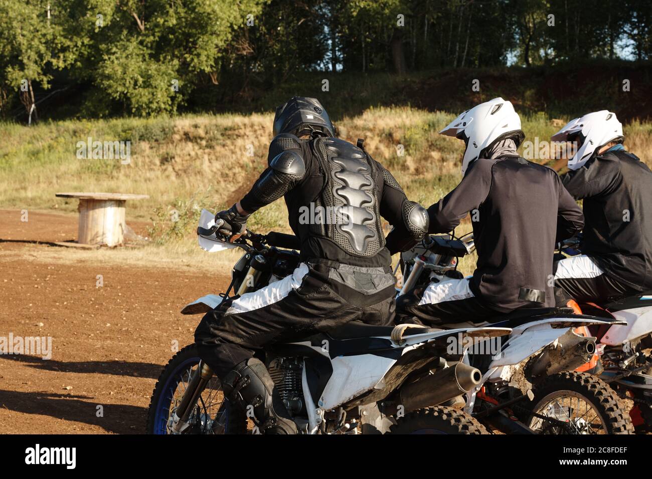 Group of three motorcyclists in helmets sitting on motorbikes and ...
