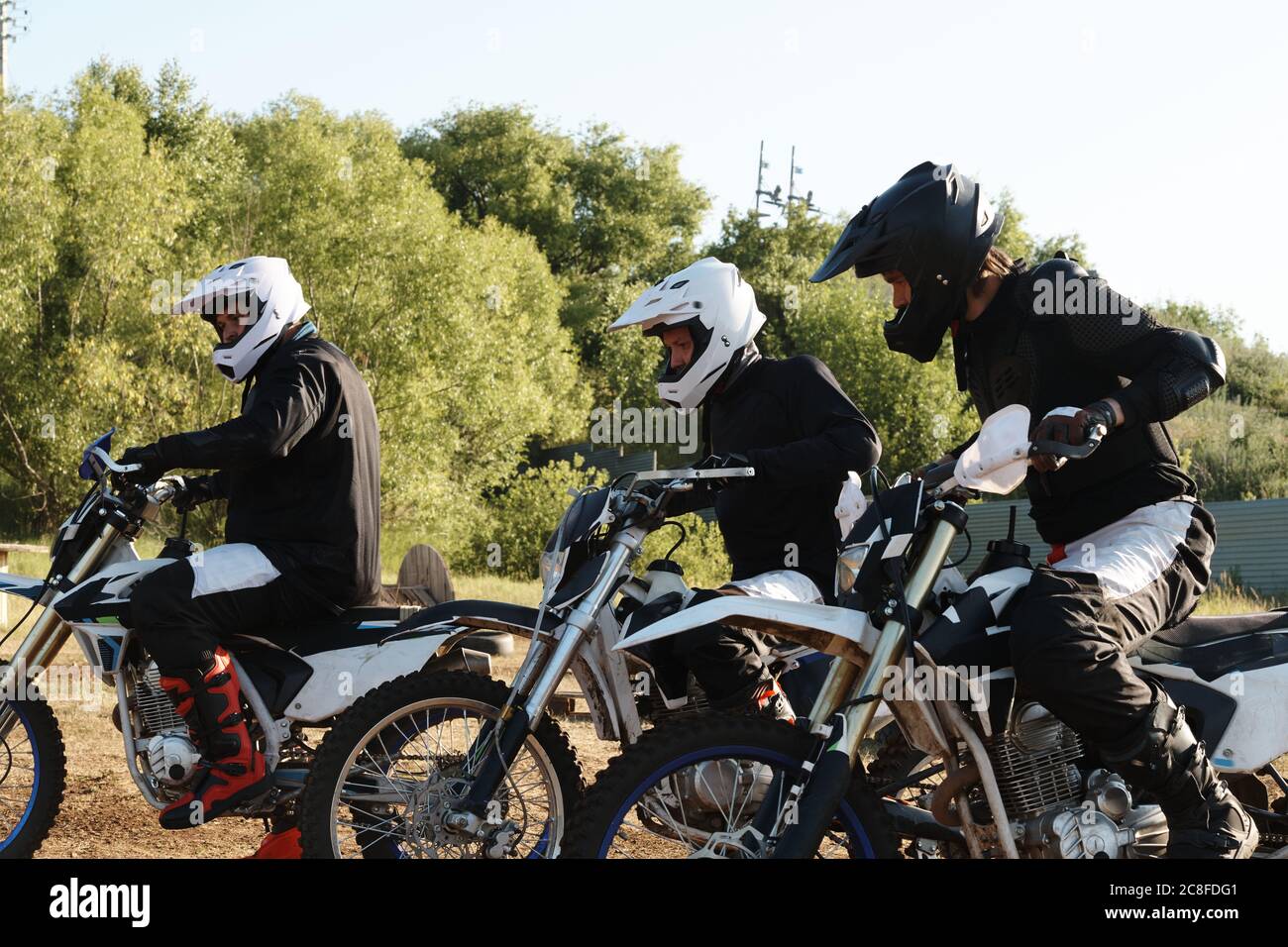 Group of male motorcyclists in helmets being at starting line while ...