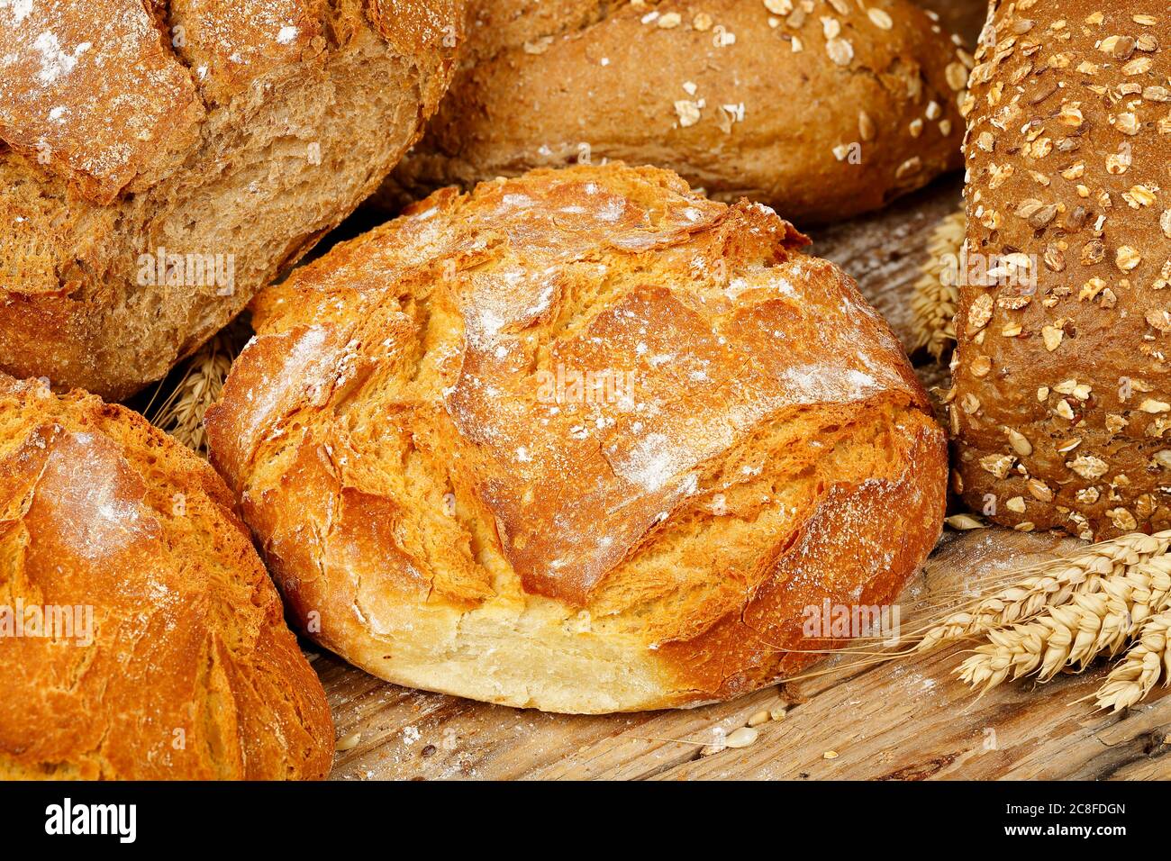 traditional round loaf of bread among others on wooden surface, full ...