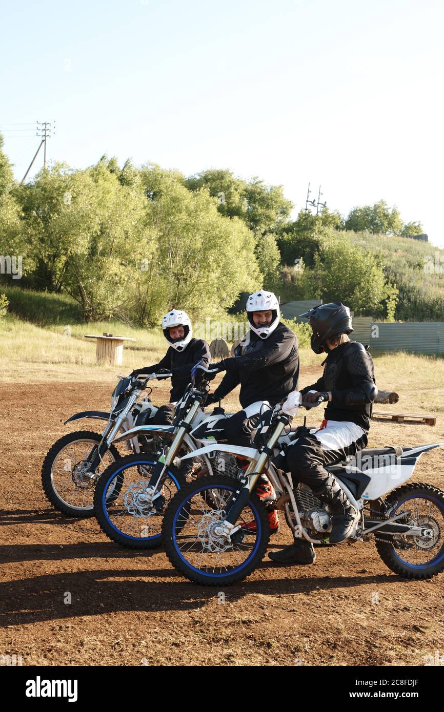 Group of motorcyclists sitting on motorbikes and talking to each other ...