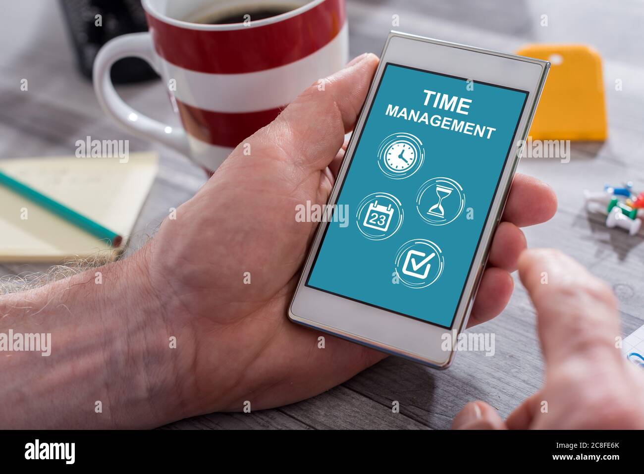 Male hand holding a smartphone with time management concept Stock Photo ...