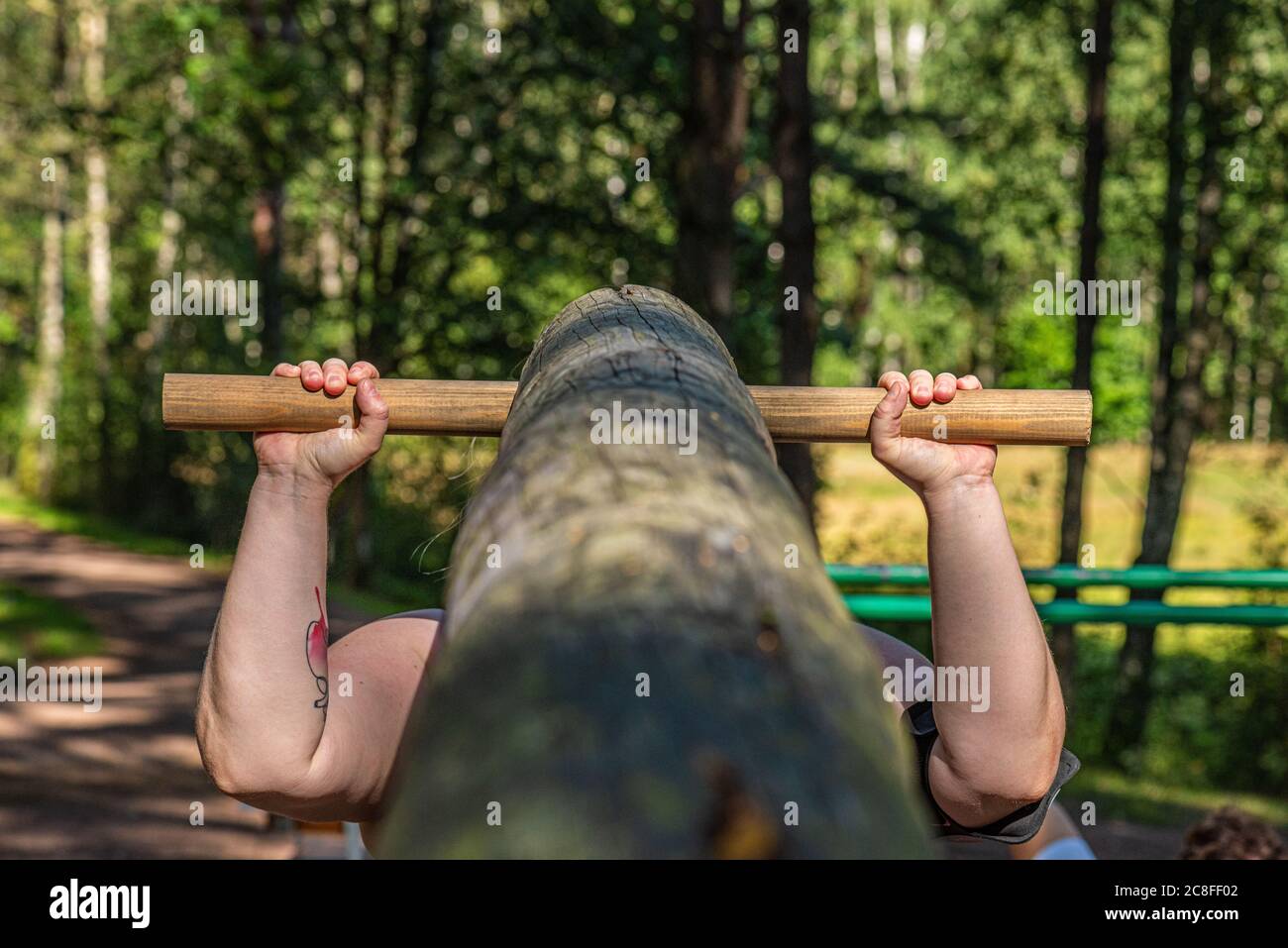 A woman lifting a log at an outdoor gym in a park Stock Photo - Alamy