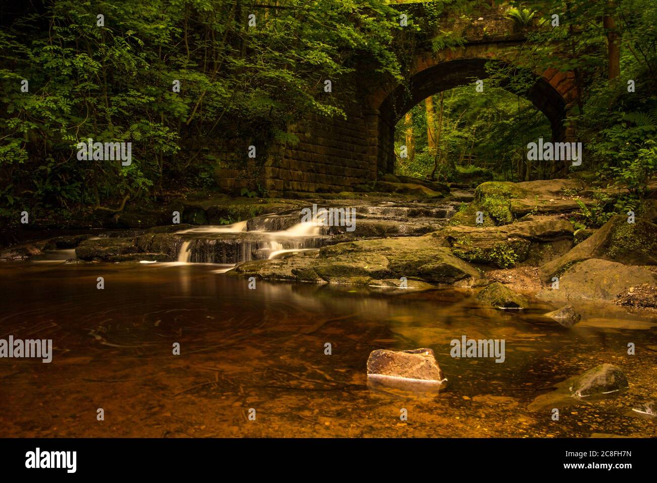Small red brick bridge over the stream at falling foss waterfall Stock ...
