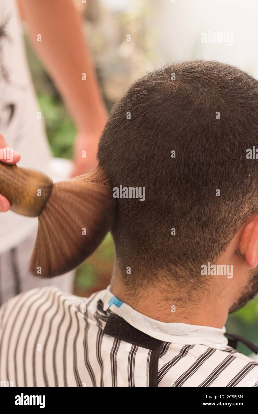 Vertical shot of a young male getting a new stylish haircut in the ...