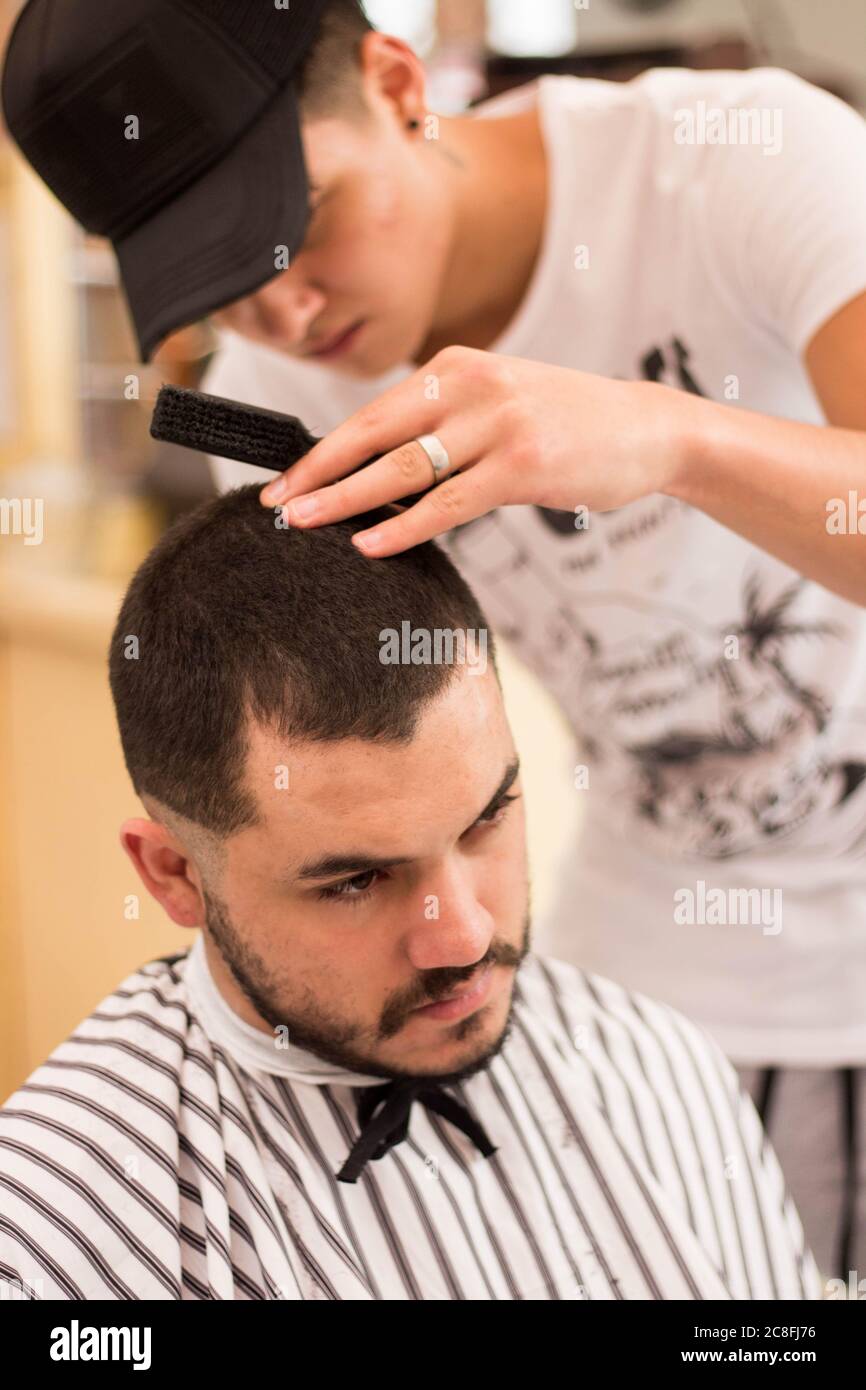 Vertical shot of a young male getting a new stylish haircut in the ...