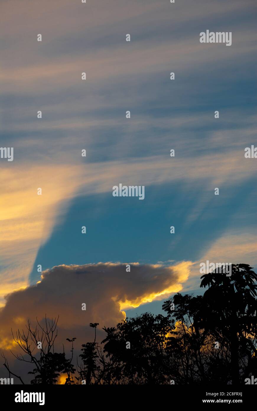 Sunset with clouds and shadows with partially clear sky, shadows cast ...