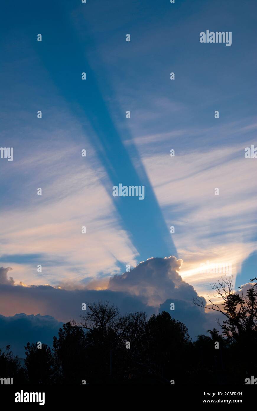 Sunset with clouds and shadows with partially clear sky, shadows cast ...