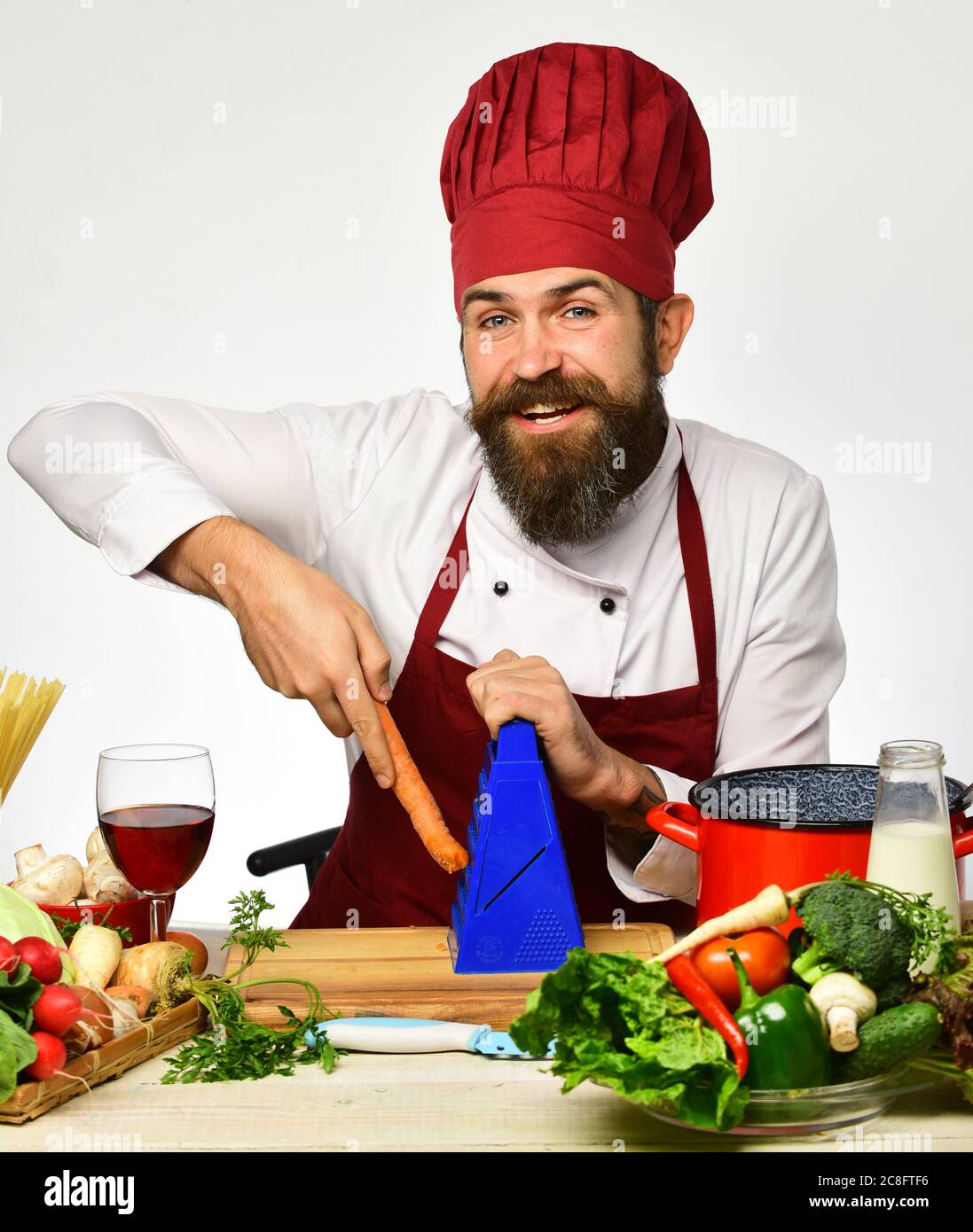 Cooking process concept. Man with beard grates carrot on grater on ...