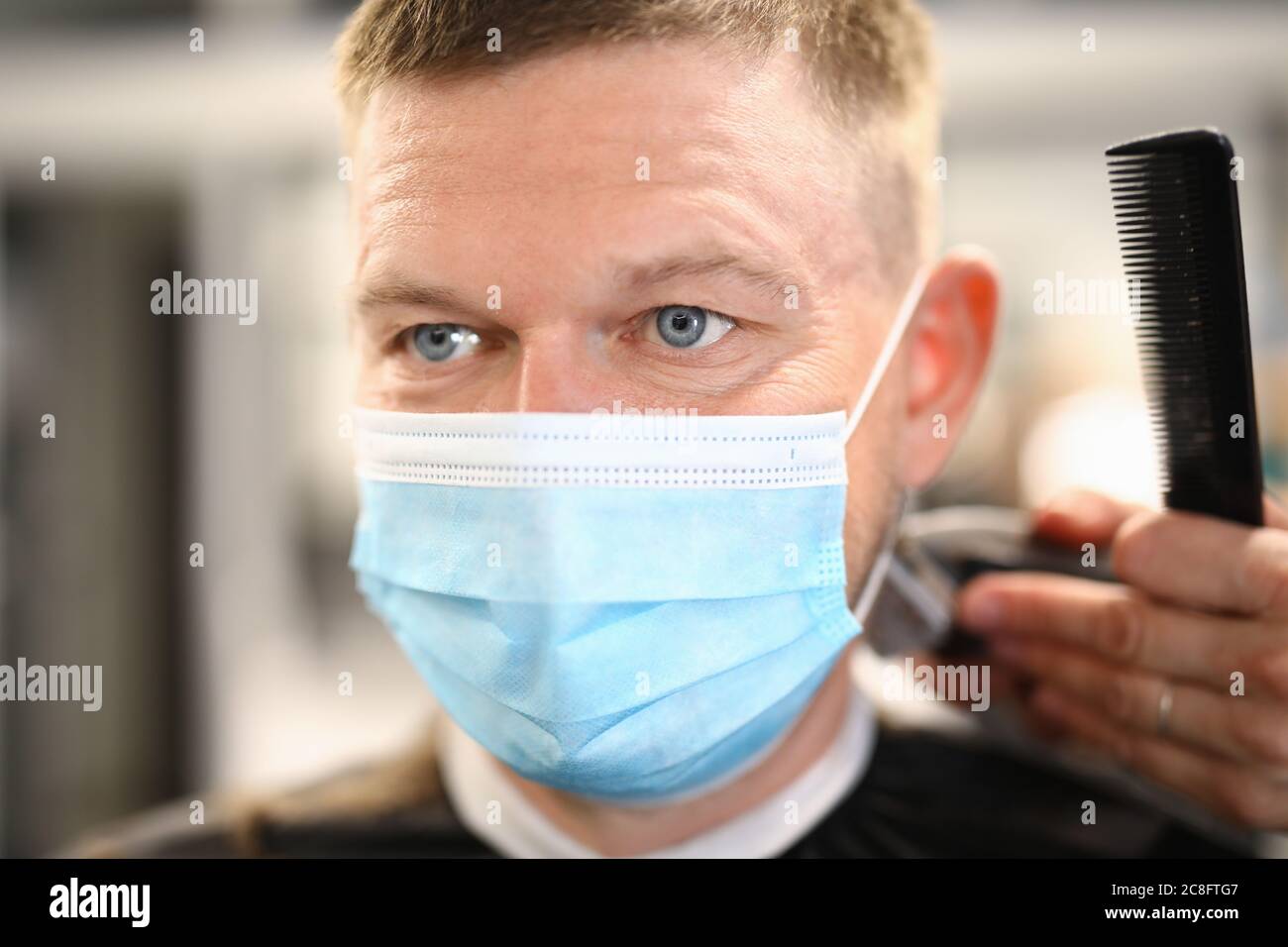 Man in medical mask has haircut in hairdressing salon Stock Photo - Alamy