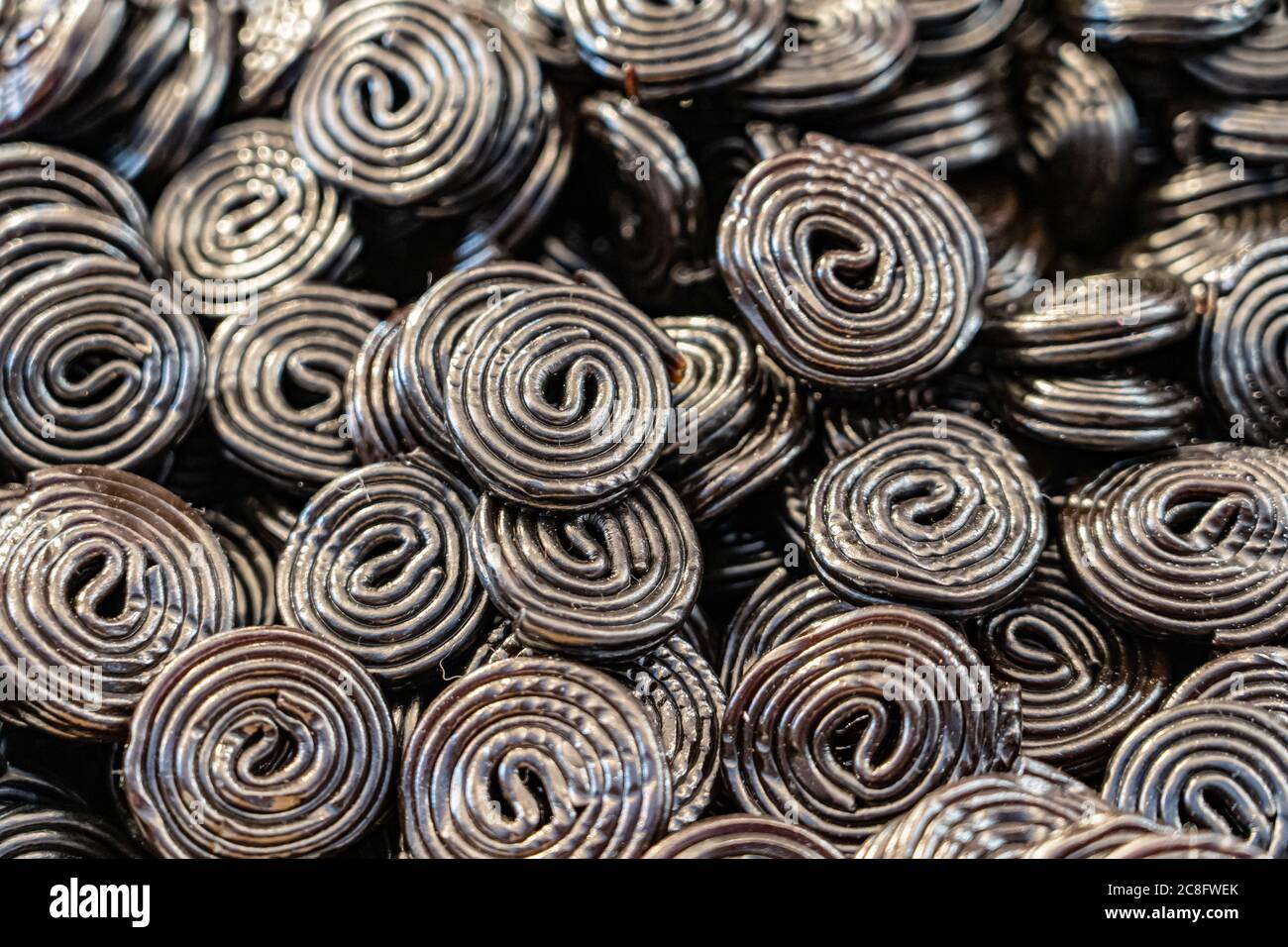 Sweet black candy spiral background Stock Photo - Alamy