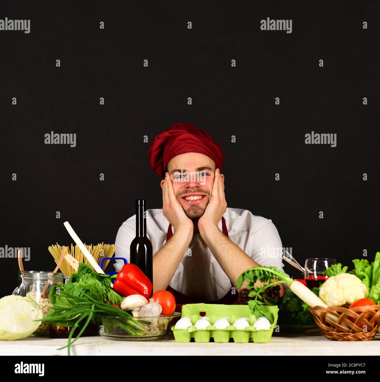Food preparation concept. Cook sits in kitchen near table with ...