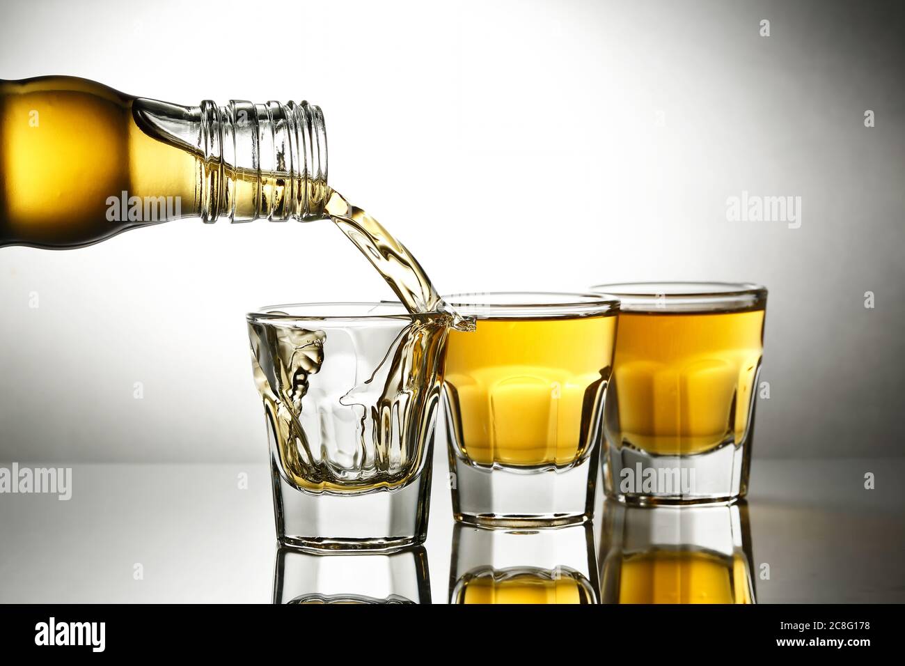 pouring whiskey into shot glasses Stock Photo - Alamy