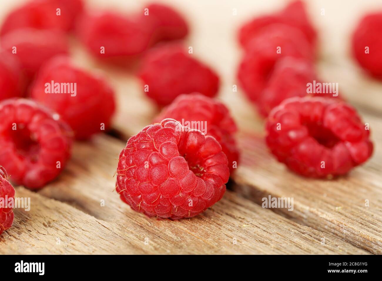 macro of ripe raspberries on weathered wood Stock Photo - Alamy