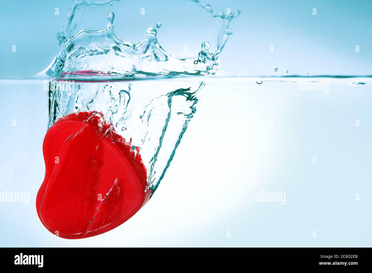 red heart sinking in water closeup Stock Photo - Alamy